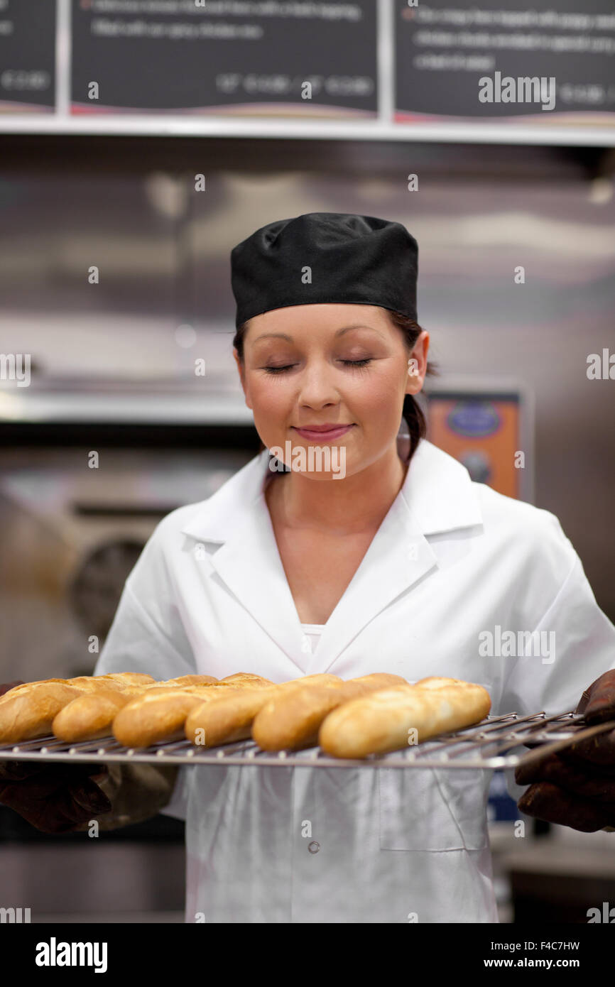 Cute young baker smelling baguettes Stock Photo - Alamy