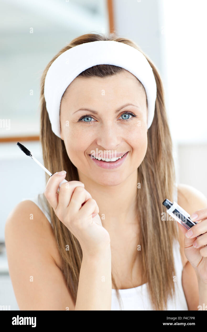 Radiant young woman using mascara in the bathroom Stock Photo - Alamy