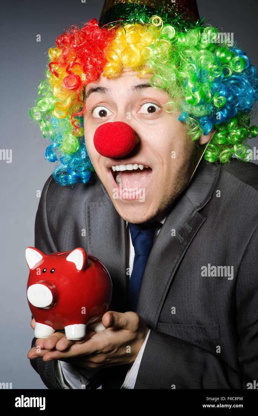 Clown with piggybank in funny concept Stock Photo - Alamy