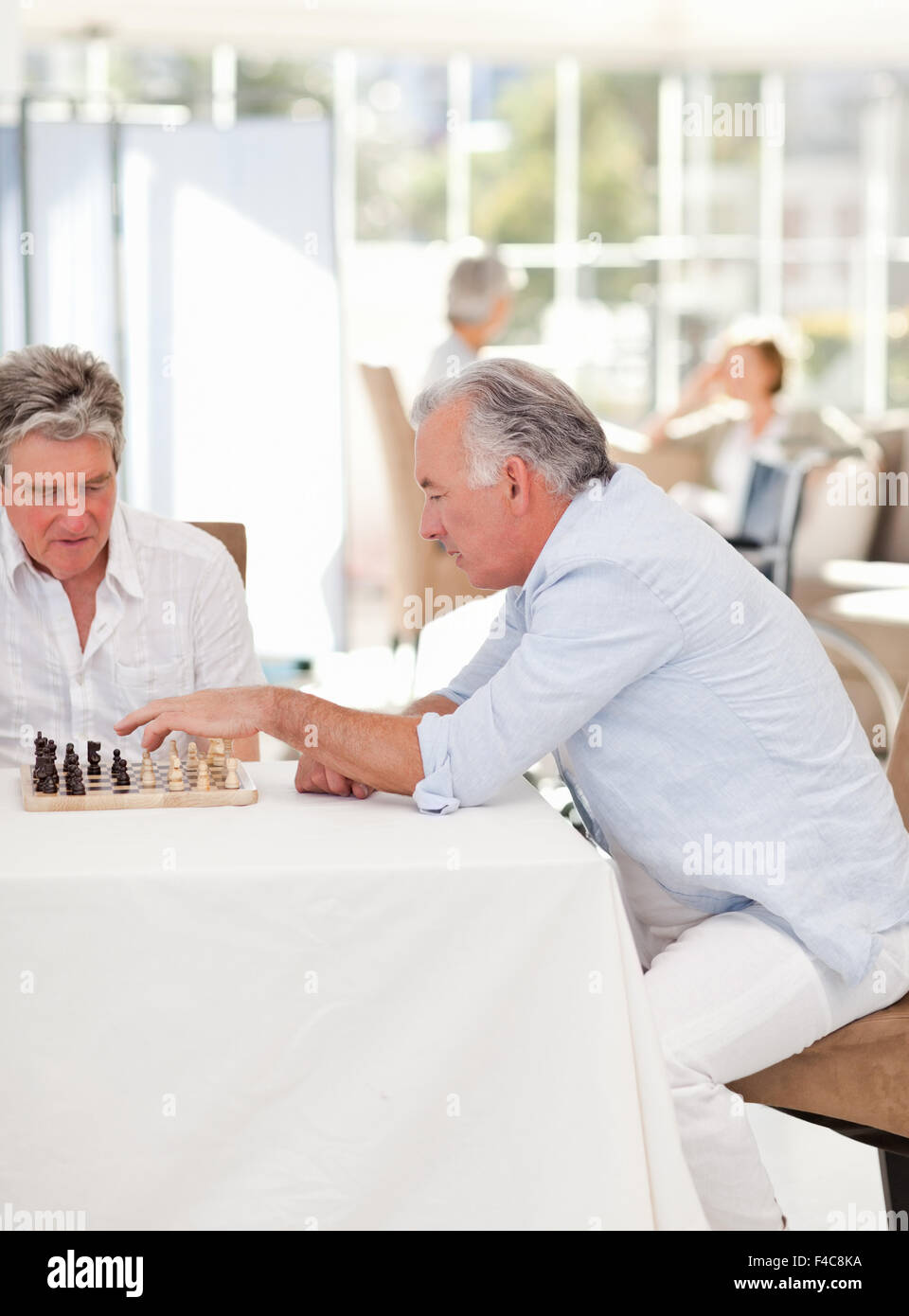 Seniors playing chess in the living room Stock Photo - Alamy