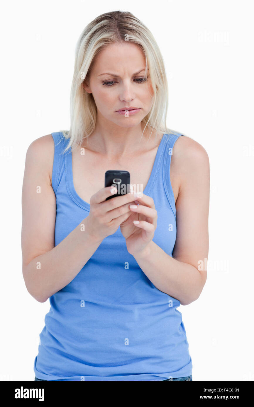 Serious woman looking at her mobile phone while concentrating Stock ...