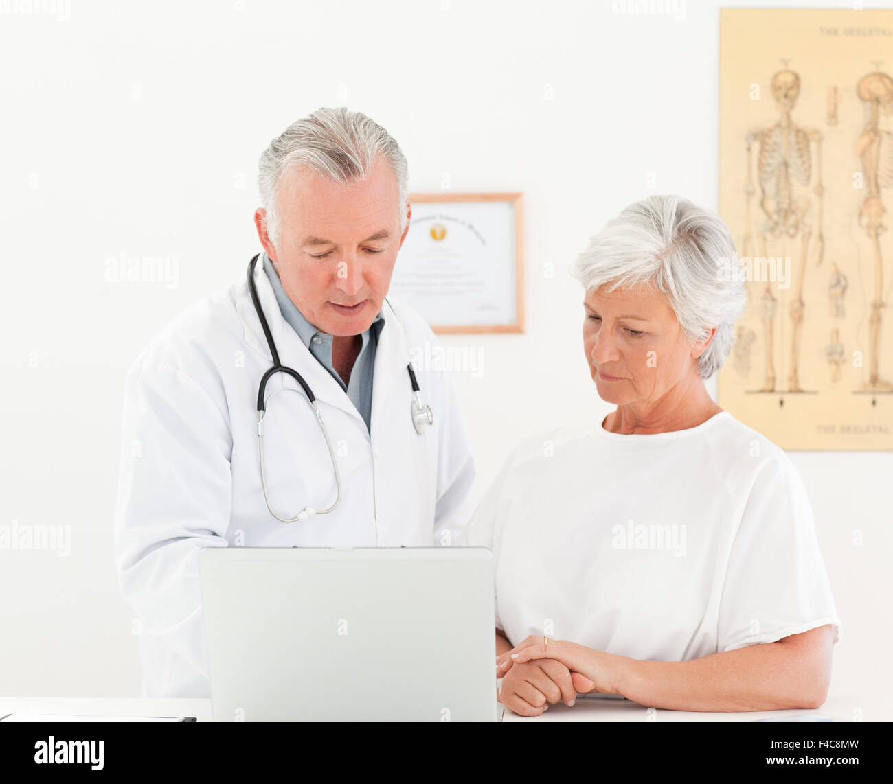 Doctor and his patient looking at the laptop Stock Photo - Alamy