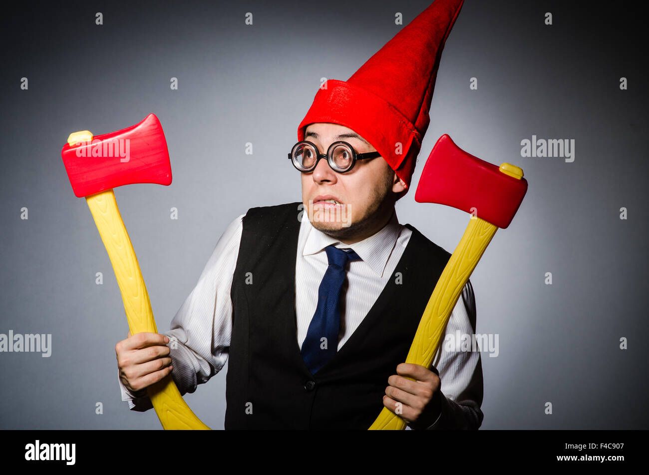Man with axes in funny concept Stock Photo - Alamy