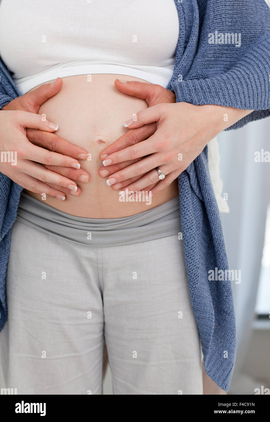 Couple's hand on the belly of the pregnant woman Stock Photo - Alamy