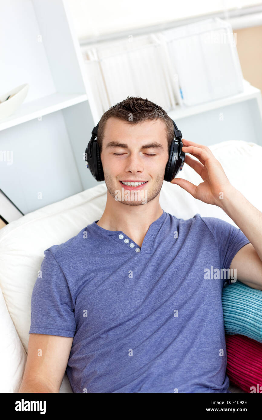 Relaxed Young Man Listening To Music Sitting On The Couch In The Living