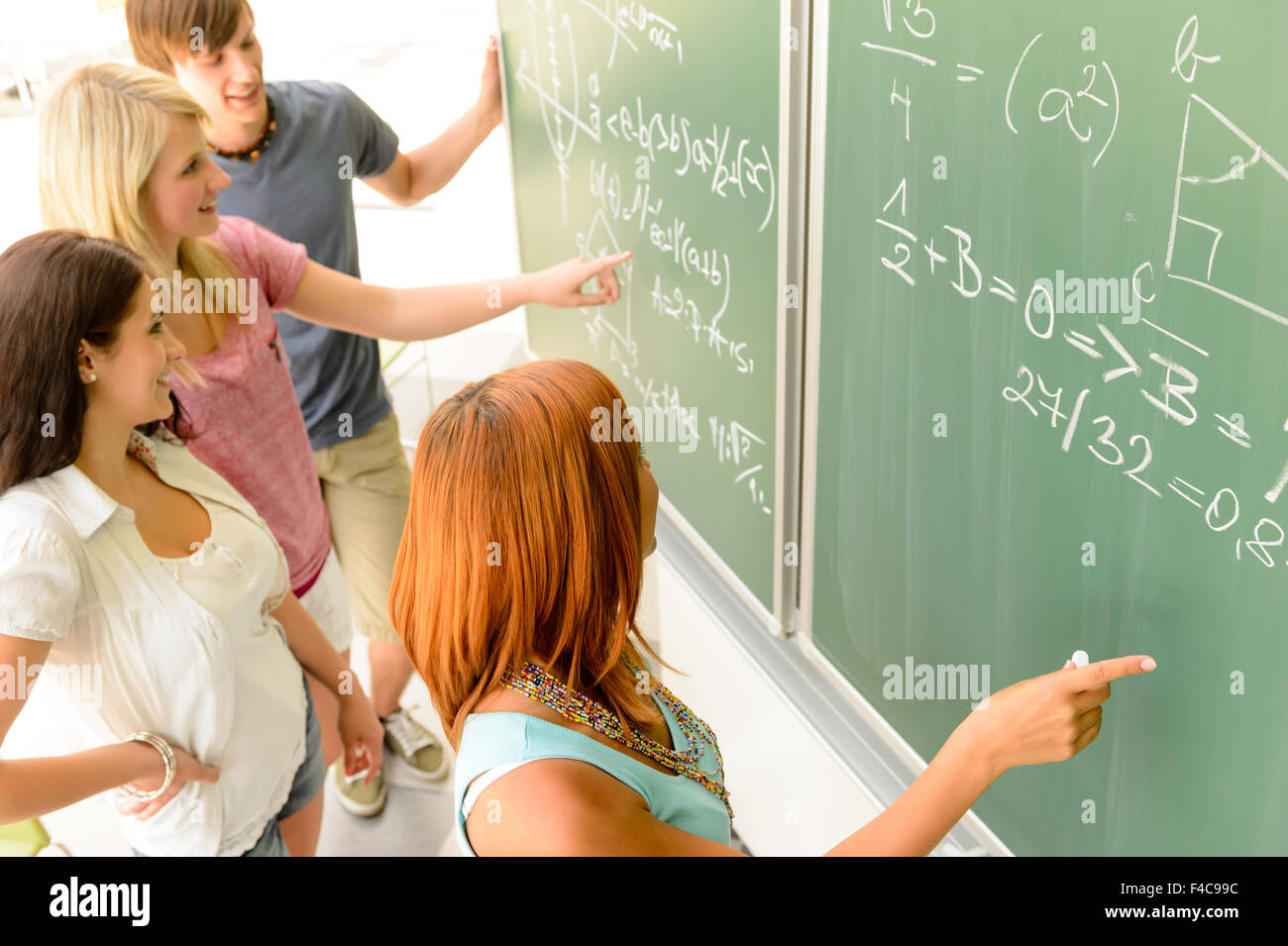 Math student write on green chalkboard classmates Stock Photo - Alamy
