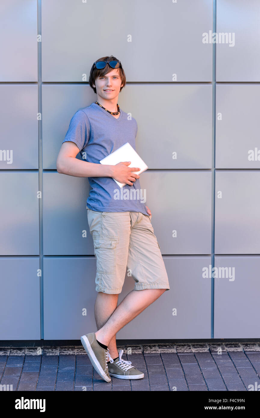 Confident college student boy with tablet standing Stock Photo - Alamy