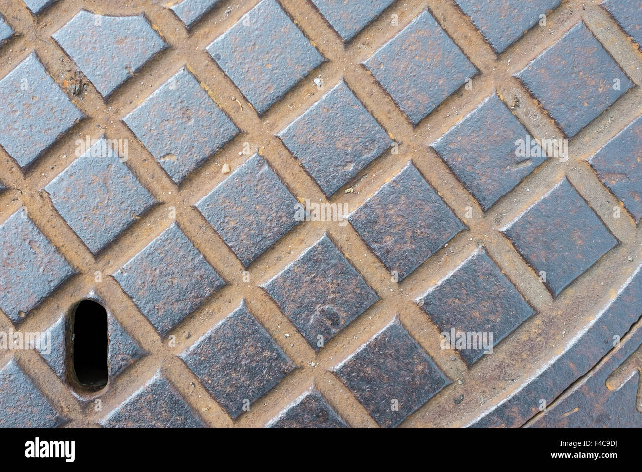 Manhole cover with hole and rust as pattern Stock Photo - Alamy