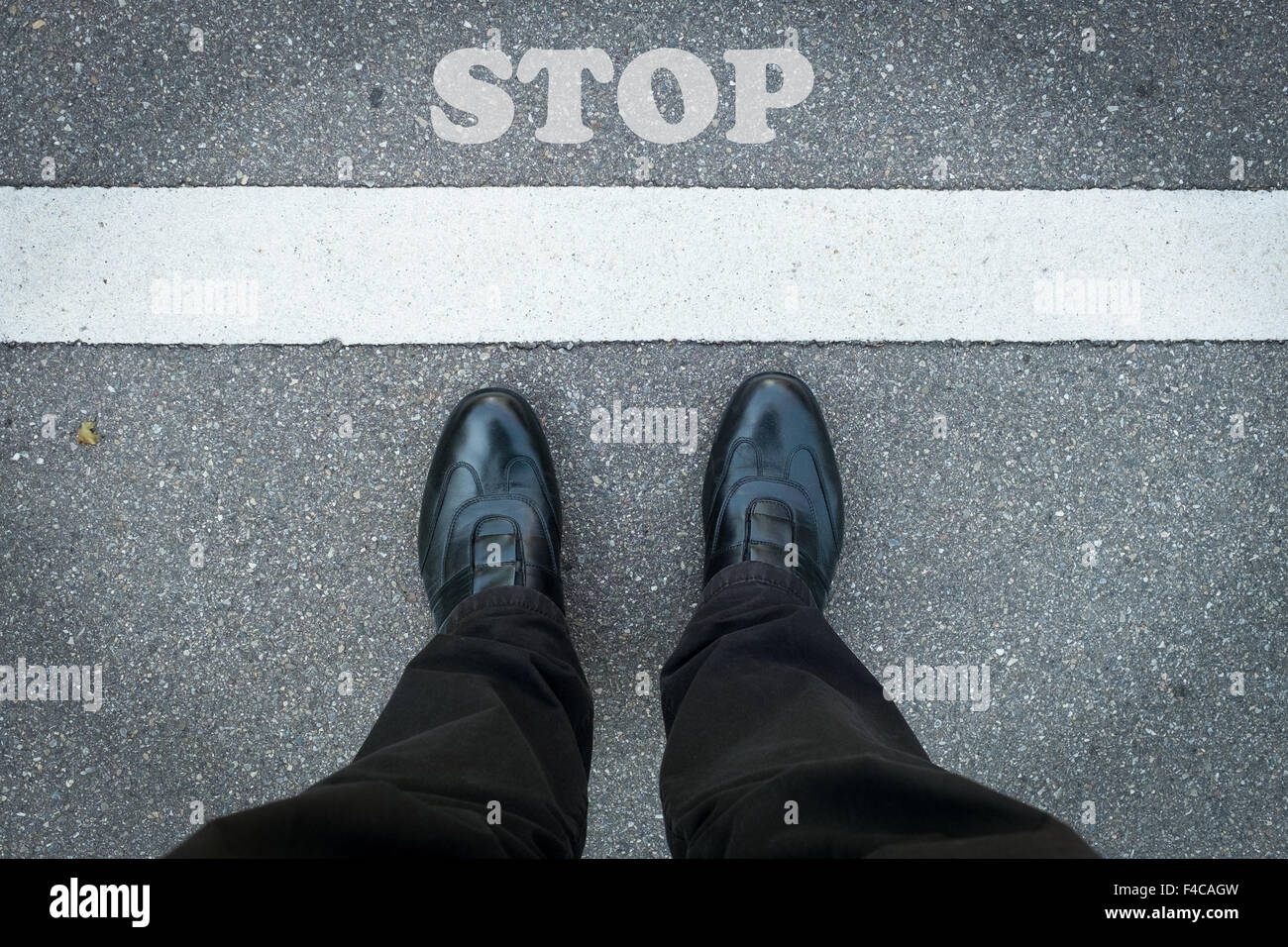 Legs of a man with stop sign on the floor Stock Photo - Alamy