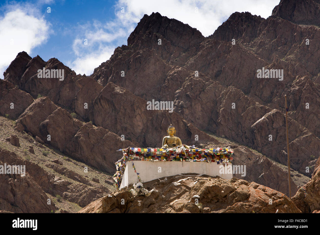 India, Jammu & Kashmir, Ladakh, Hemis, Gold Buddha statue on hillside ...