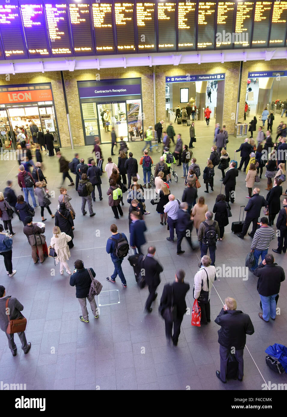 Passengers watch departures board in Kings Cross railway station ...