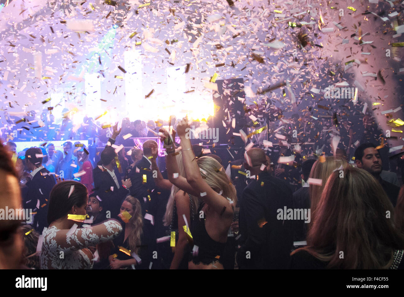 A confetti cannon sprays confetti at the dancing crowed on a club event ...