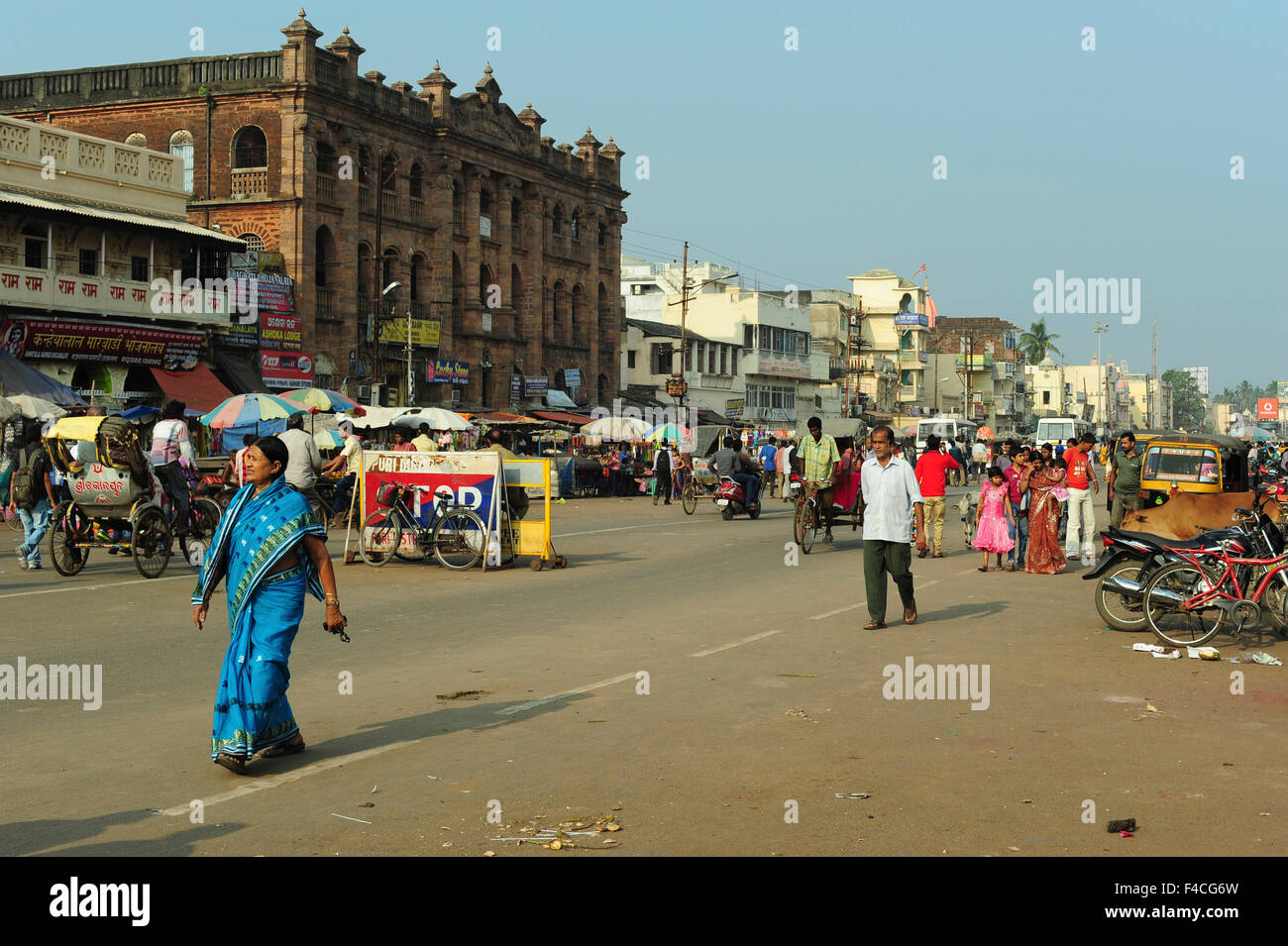 India, Odisha, Puri, street scene with pedestrian, rickshaw and cows ...