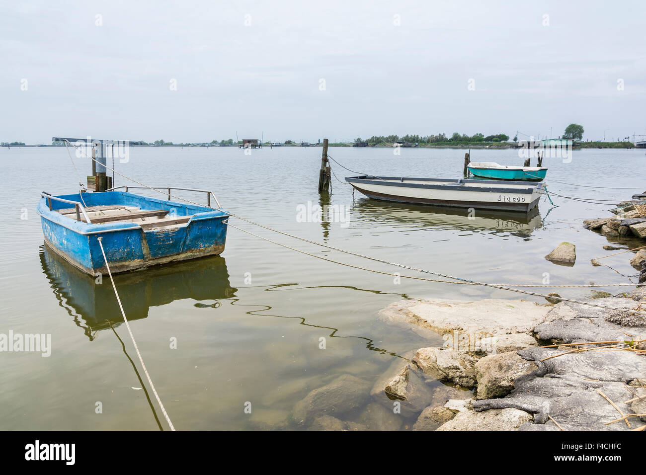 Old fishing boats moored in a swamp during a cloudy day Stock Photo - Alamy