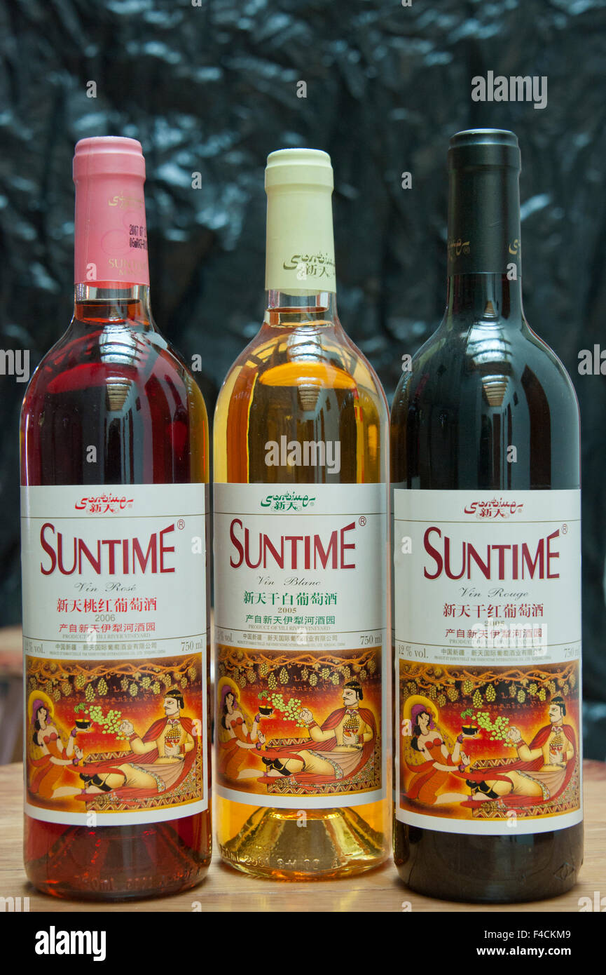 China, Xinjiang, Manas. Bottles of red, white and rose wine displayed ...
