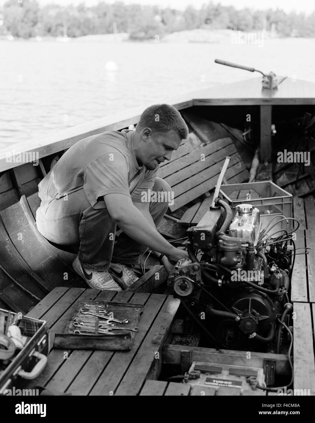 Man working on an engine in a boat Stock Photo - Alamy