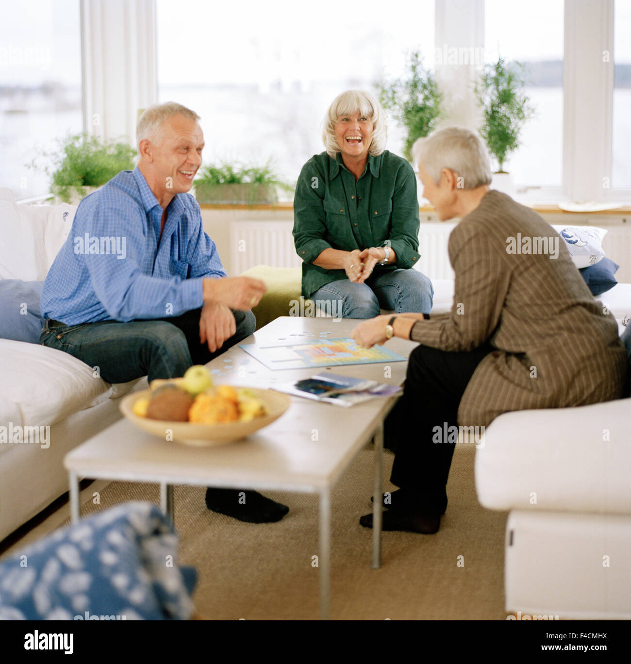 Three people together in a living room Stock Photo - Alamy