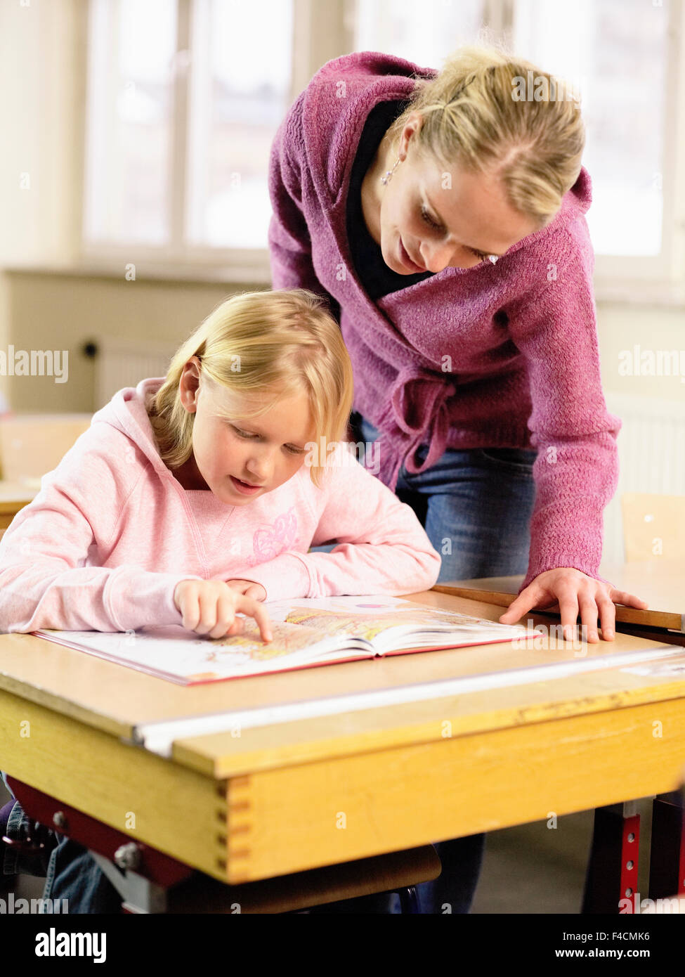 Teacher helping pupil Stock Photo - Alamy