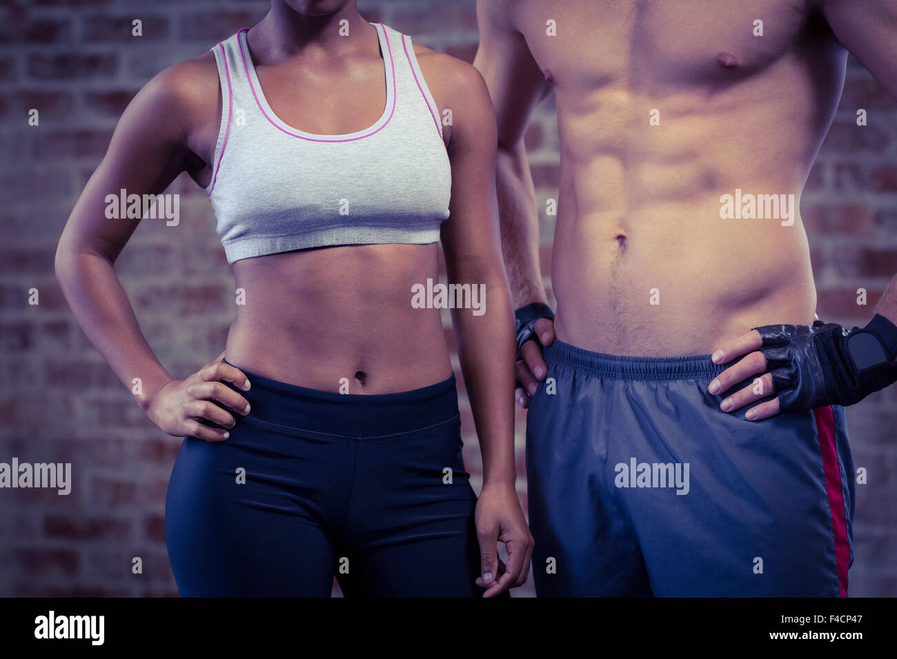 Fit couple posing with hands on hips Stock Photo - Alamy