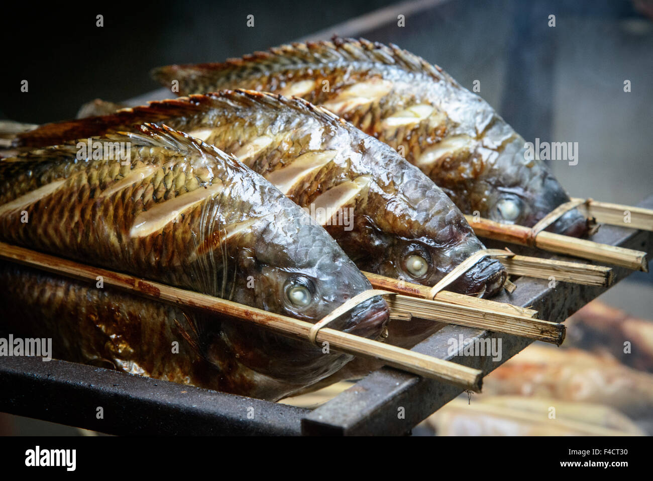Laos, Luang Prabang. Three fish being cooked. (Large format sizes ...