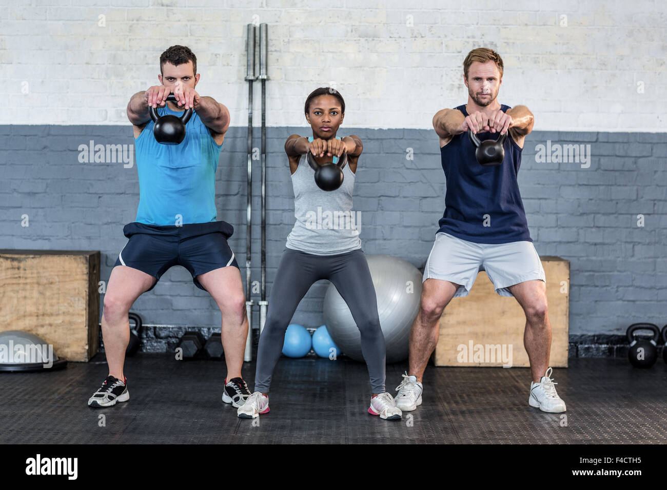 Fit people lifting kettlebells together Stock Photo - Alamy
