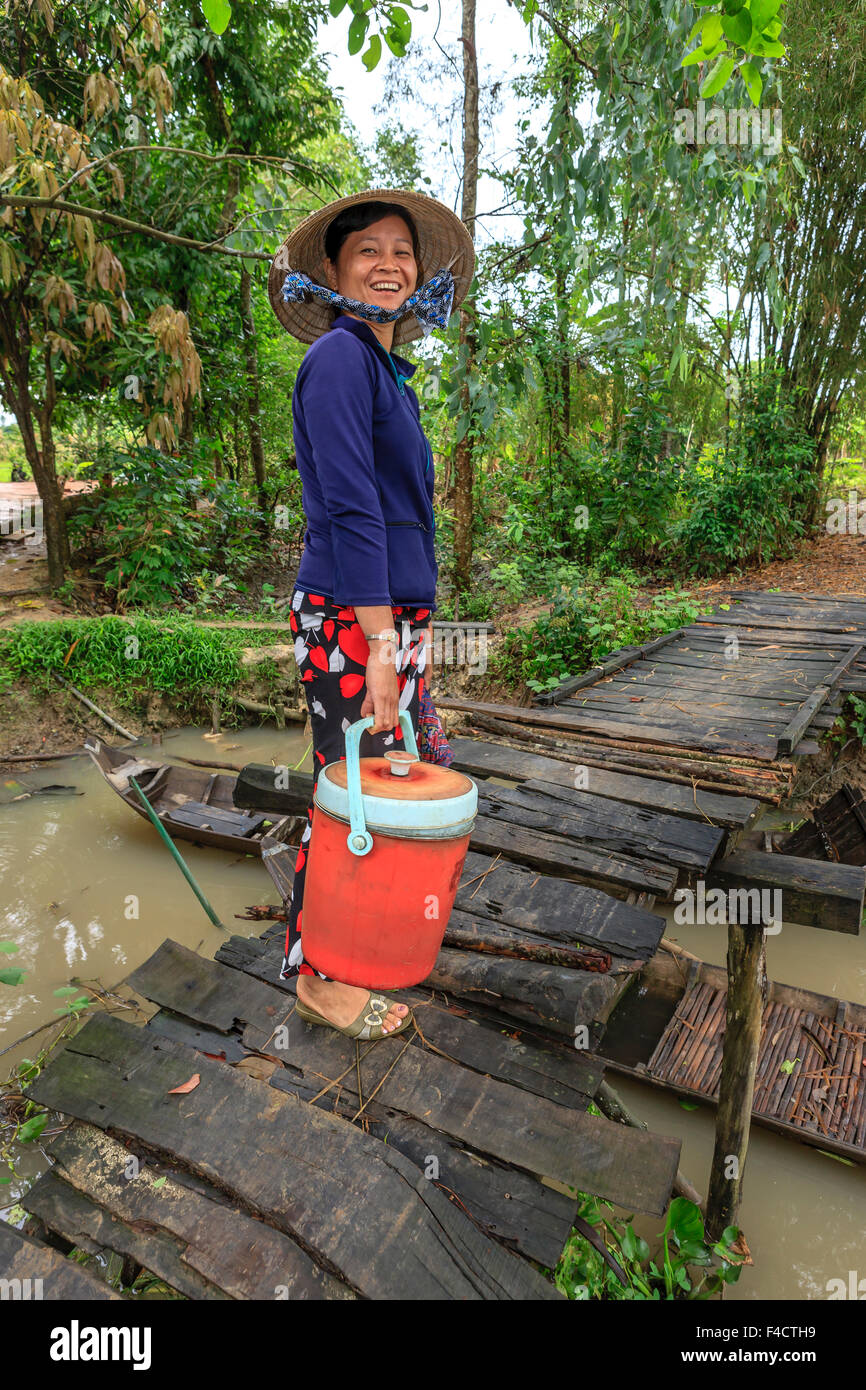 Woman fetching water over the wooden bridge. Vietnam, Indochina, South ...