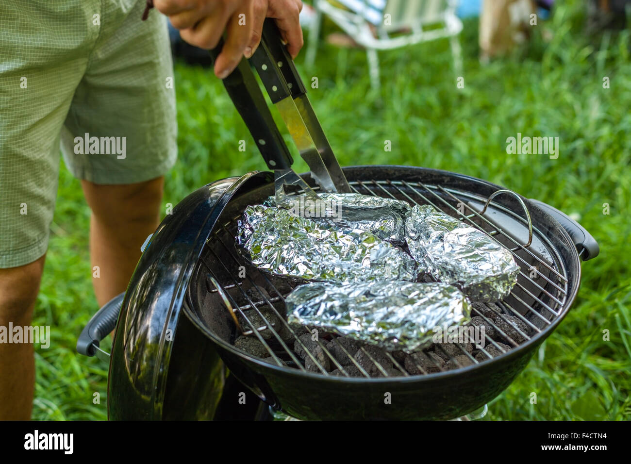 Grilling meat with barbecue stuff. Horizontal close up shot with a ...