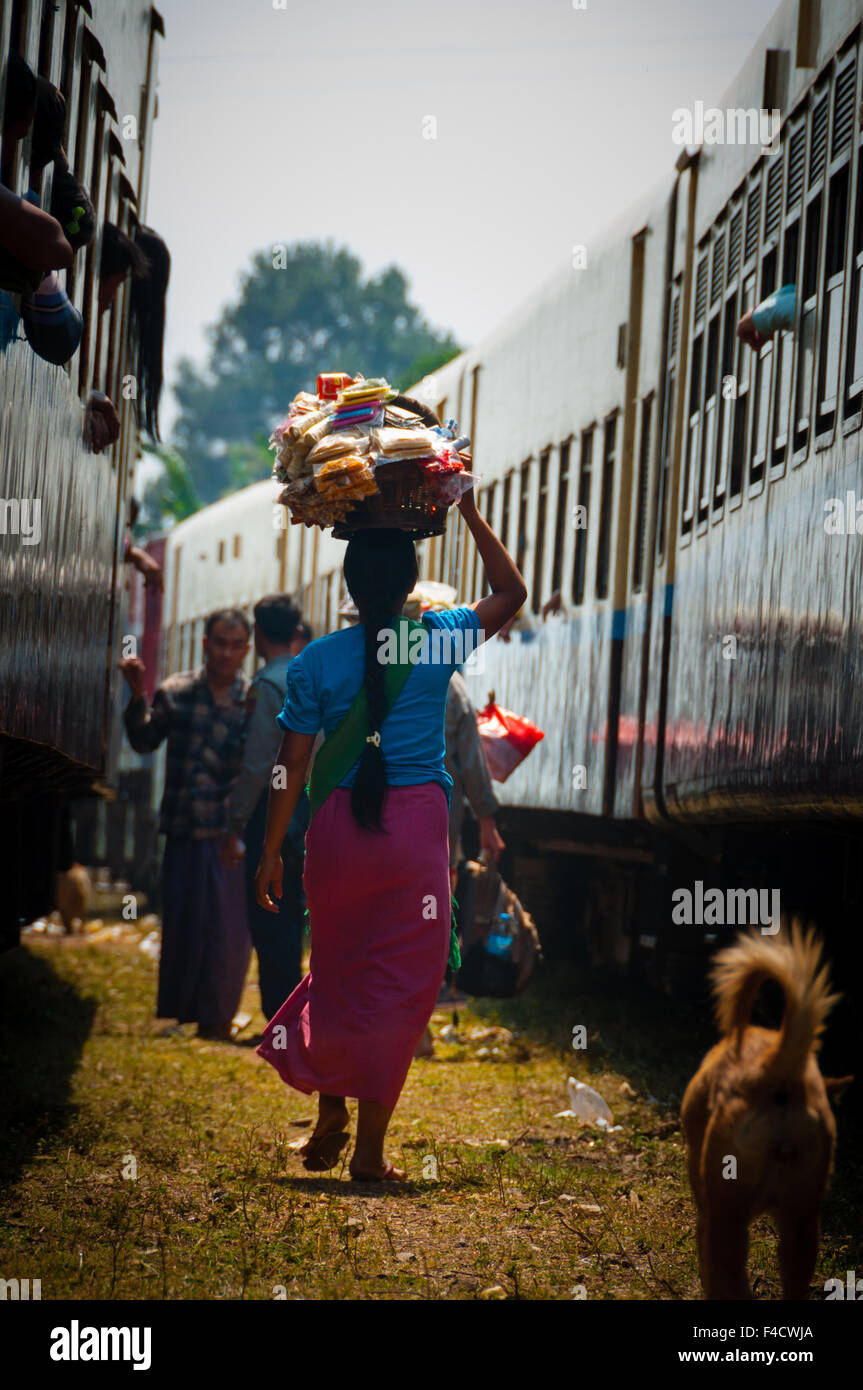Asian woman between trains from behind carrying stuff Stock Photo - Alamy