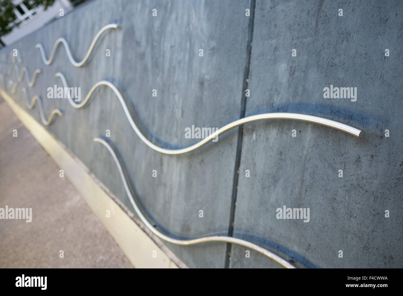Waves of stainless steel bars on concrete stone Stock Photo - Alamy