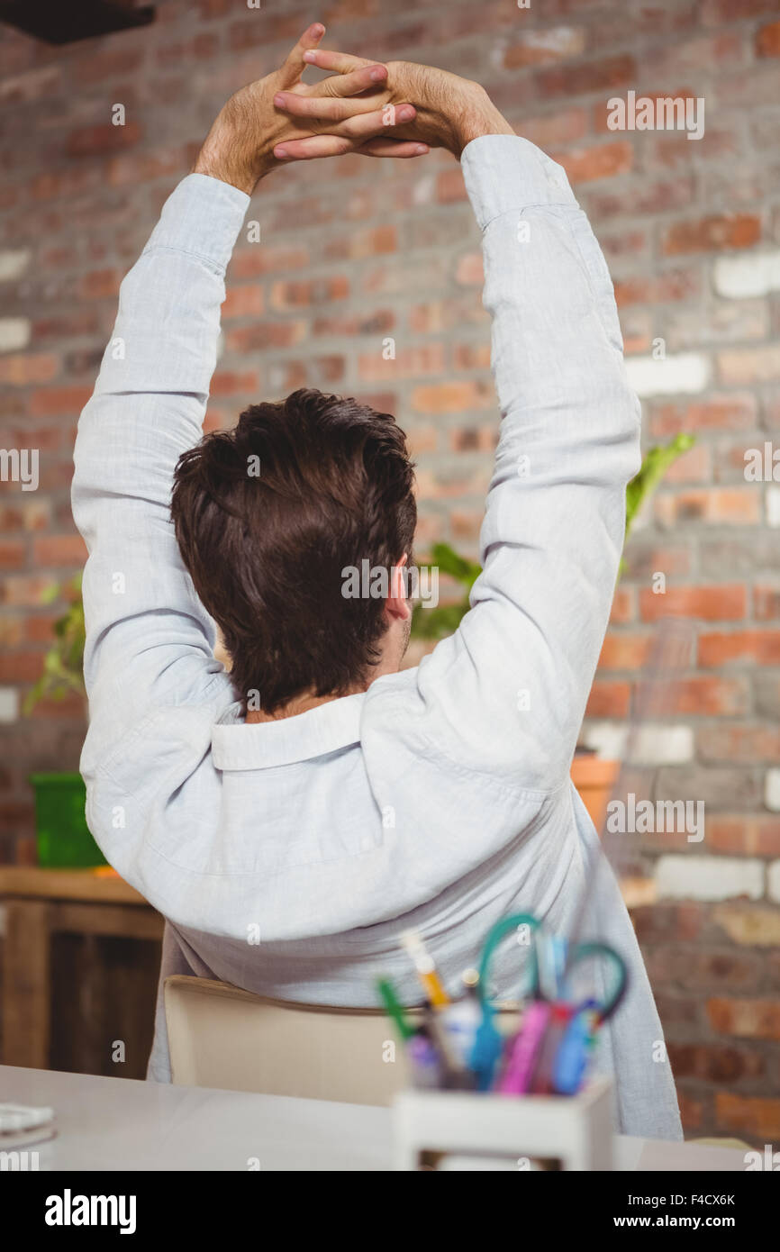 Rear view of man stretching at office Stock Photo - Alamy