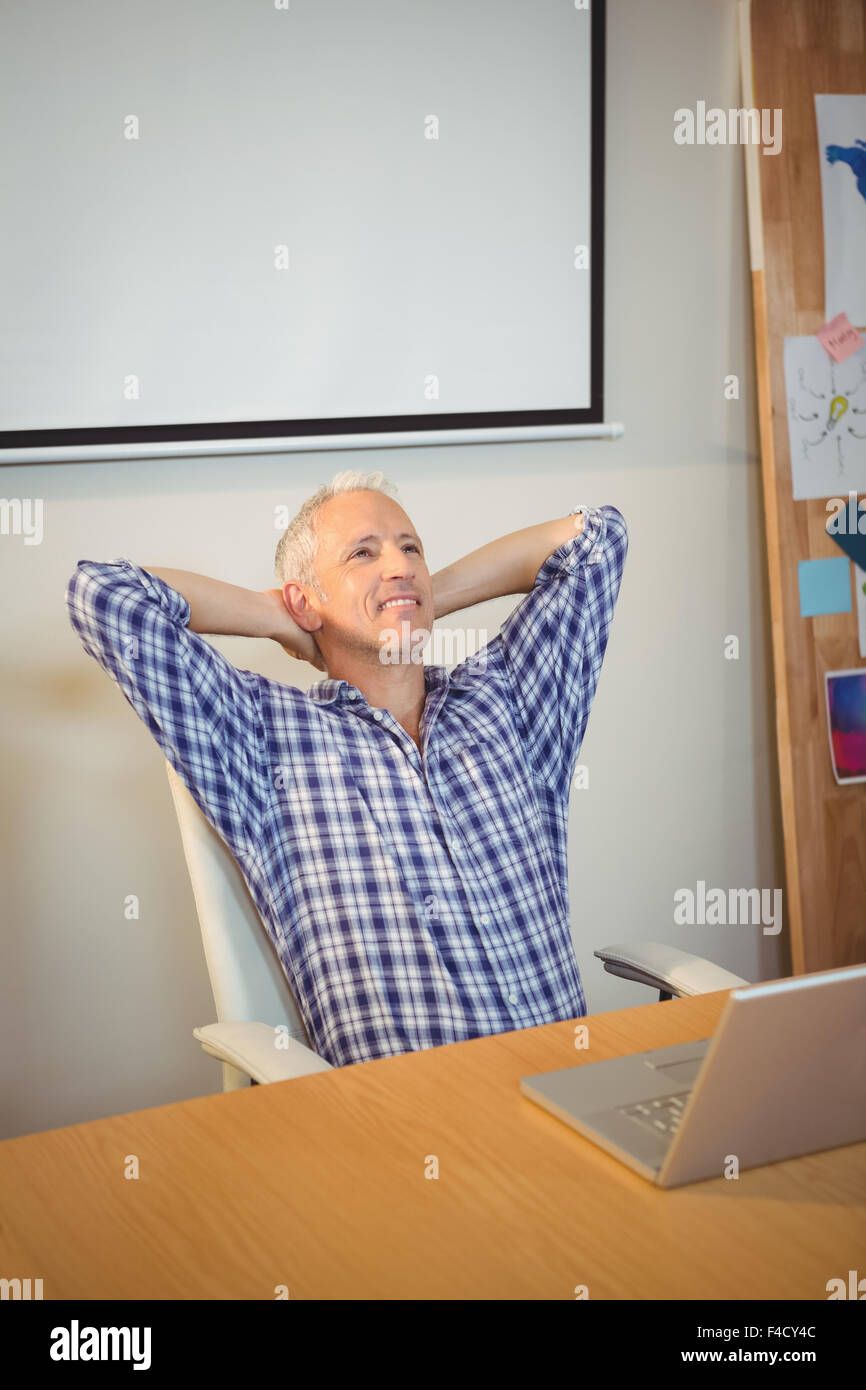Creative businessman relaxing on chair in office Stock Photo - Alamy