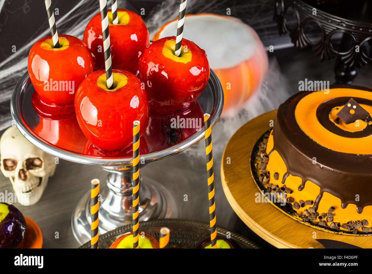 Table with colored candy apples and cake for Halloween party Stock ...