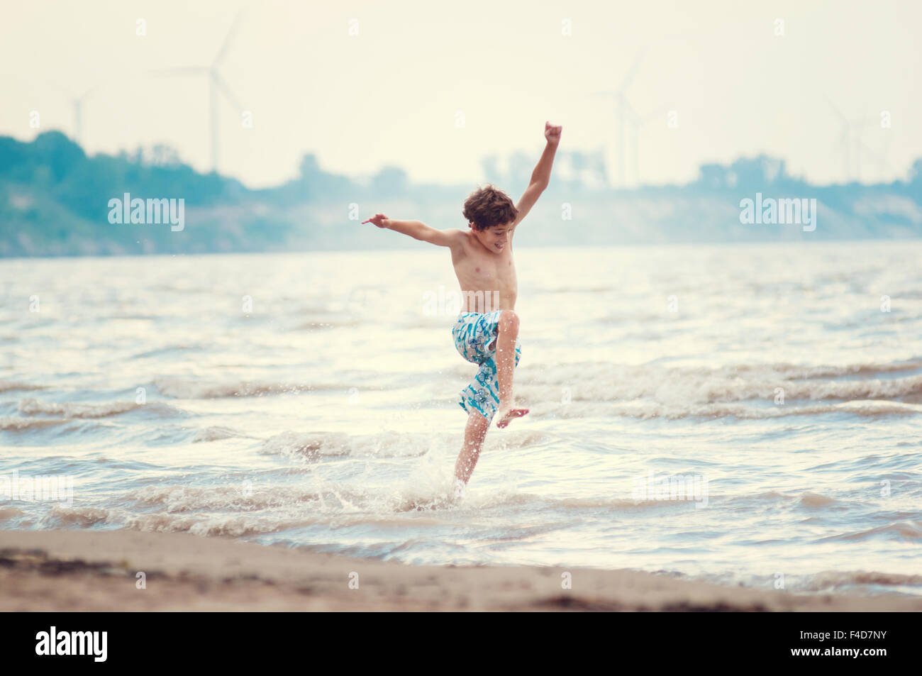 happy boy jumping in the waves at a beach in summer Stock Photo - Alamy