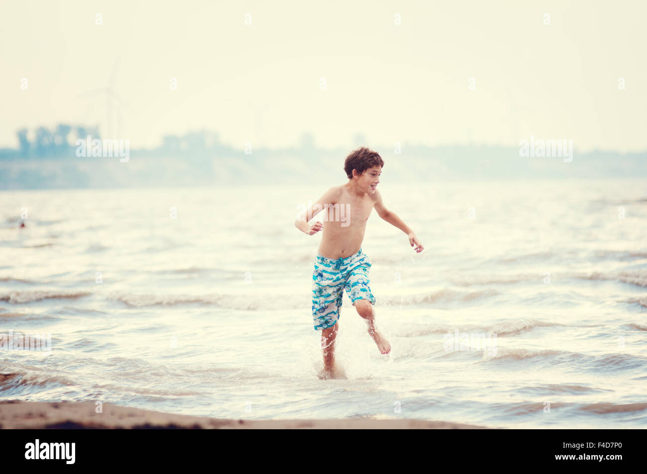 happy boy jumping in the waves at a beach in summer Stock Photo - Alamy