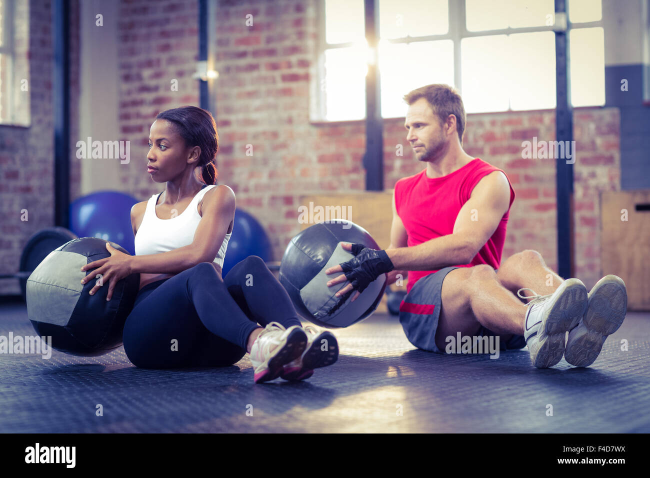 Muscular couple doing ball exercise Stock Photo - Alamy