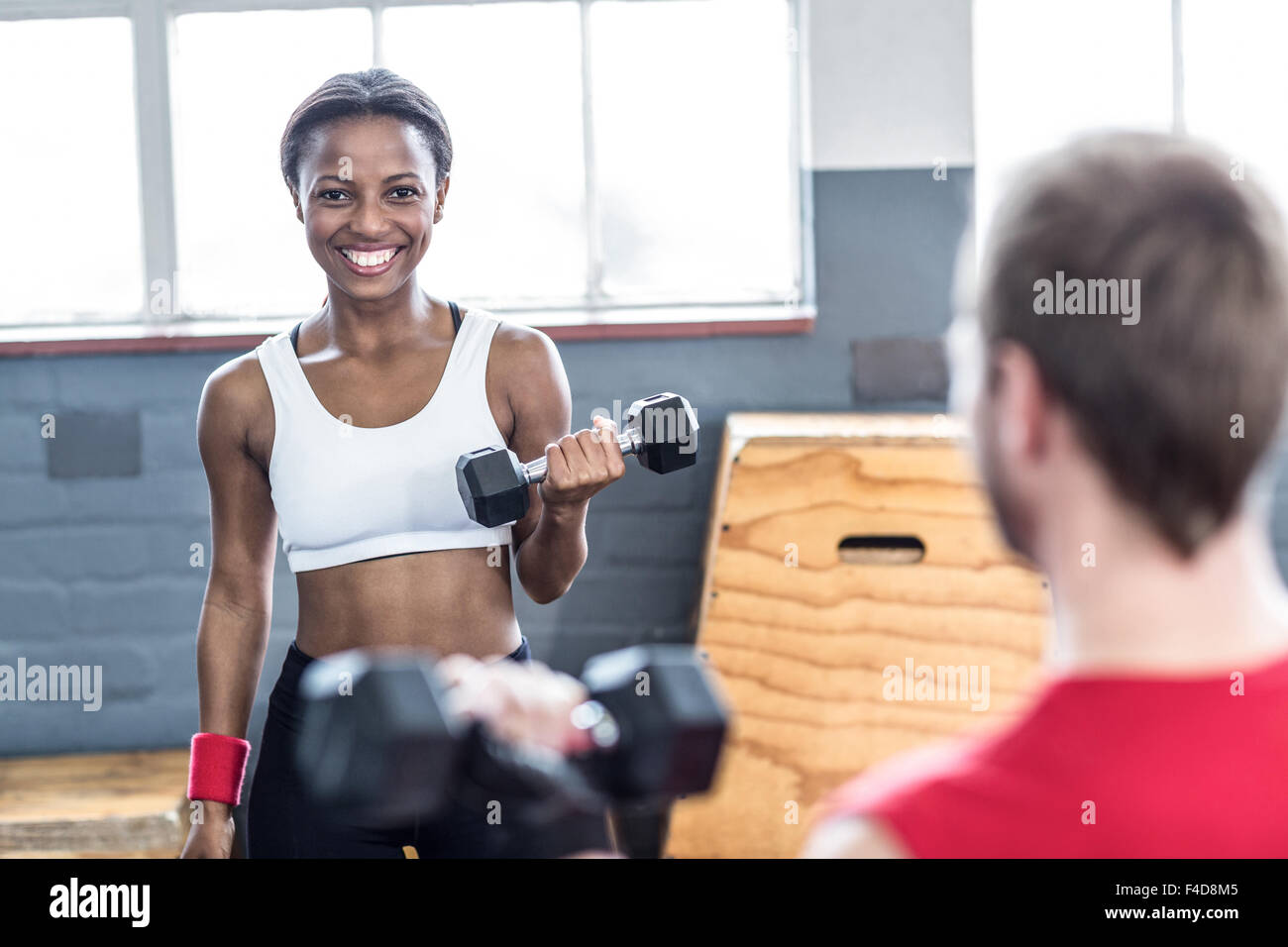Portrait of smiling woman lifting weight Stock Photo - Alamy