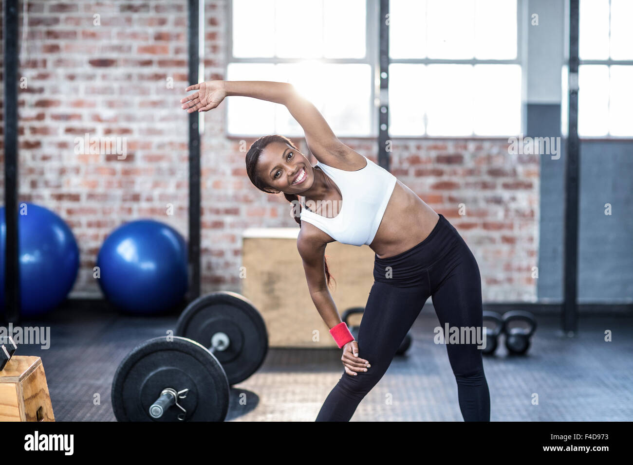 Muscular smiling woman doing some stretching Stock Photo - Alamy