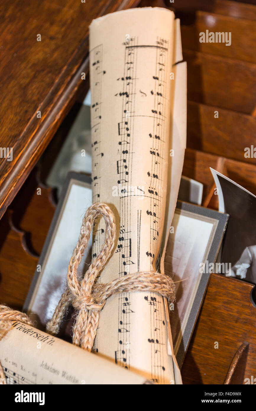 Rolled Music Sheet with aged photo over wooden drawer, composition ...