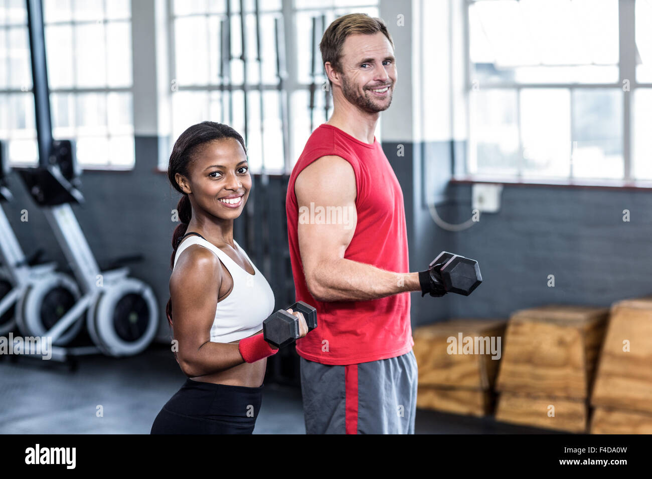 Muscular couple lifting weight together Stock Photo - Alamy