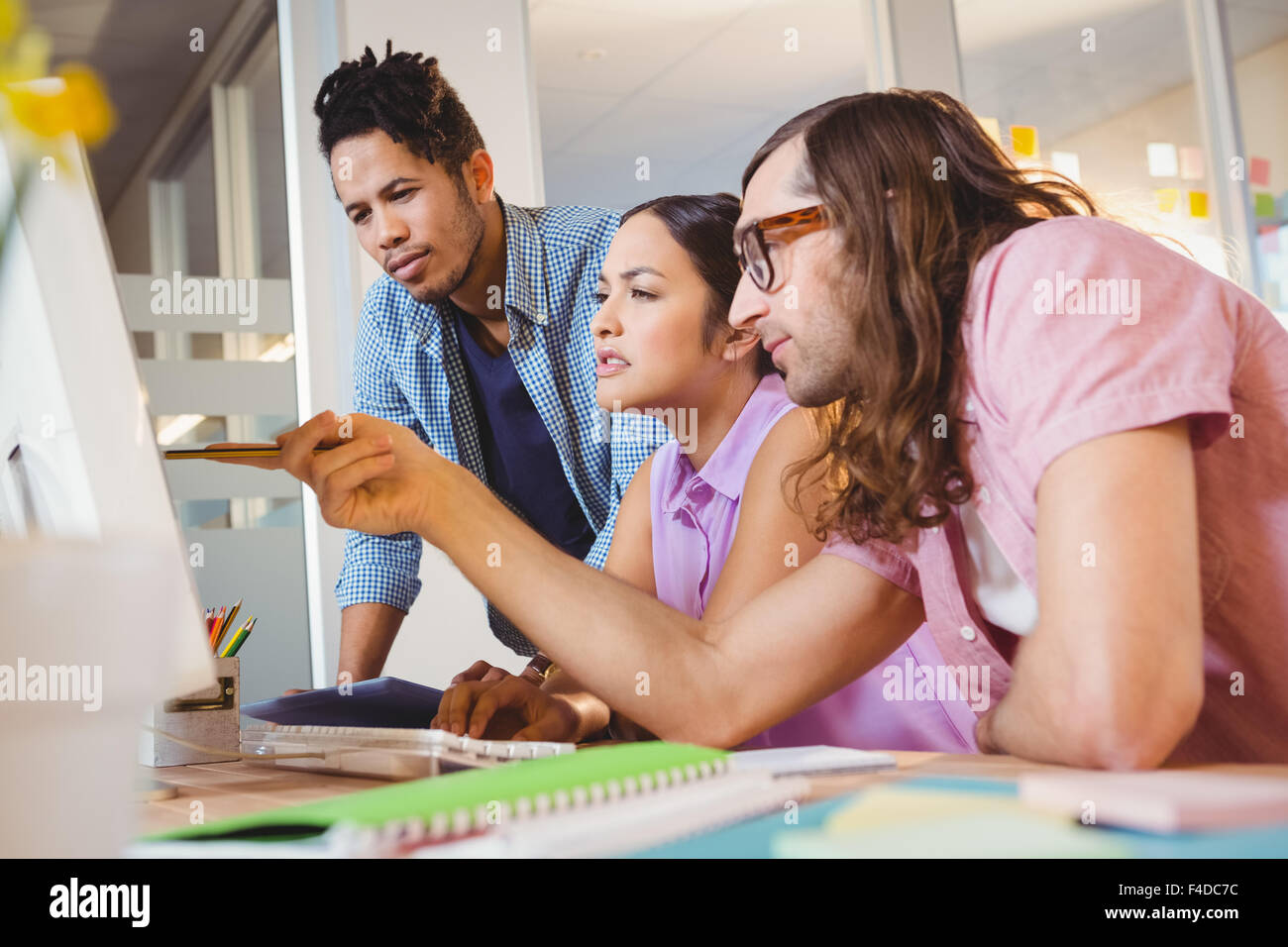 Businessman pointing at computer while explaining colleagues Stock ...