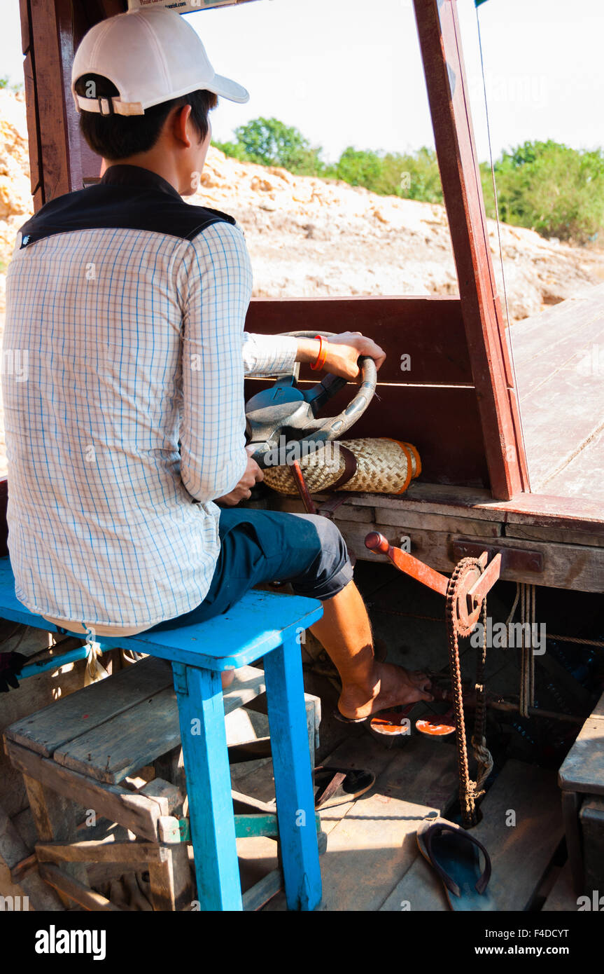 Asian boy driving boat on river Stock Photo - Alamy
