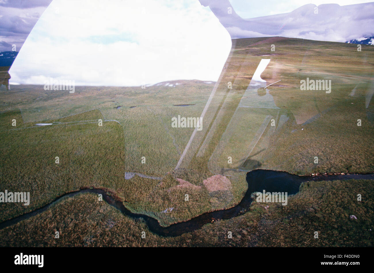 Reflection of land with creek on aircraft glass, aerial view Stock ...