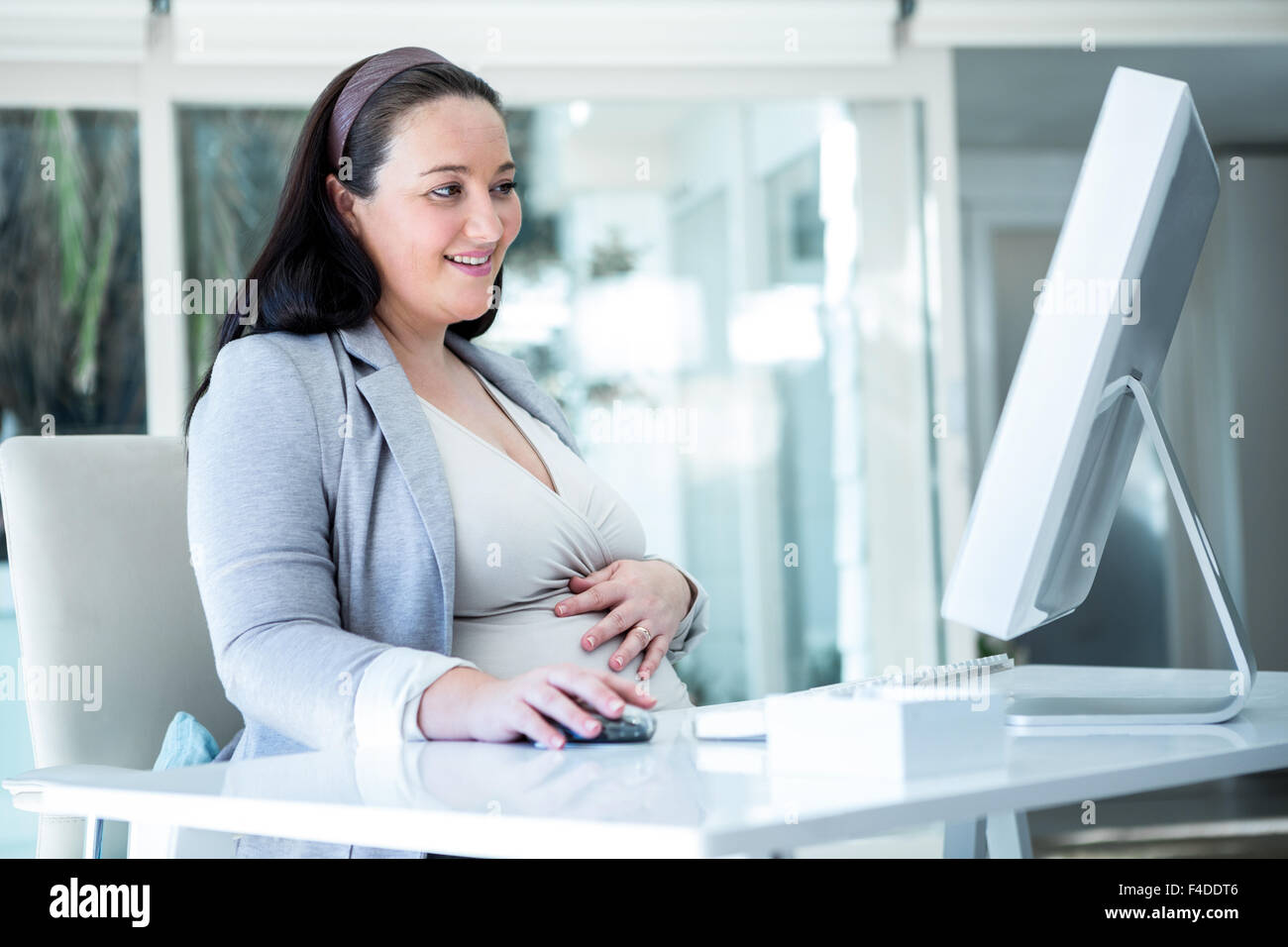 Pregnant businesswoman working on her computer Stock Photo - Alamy