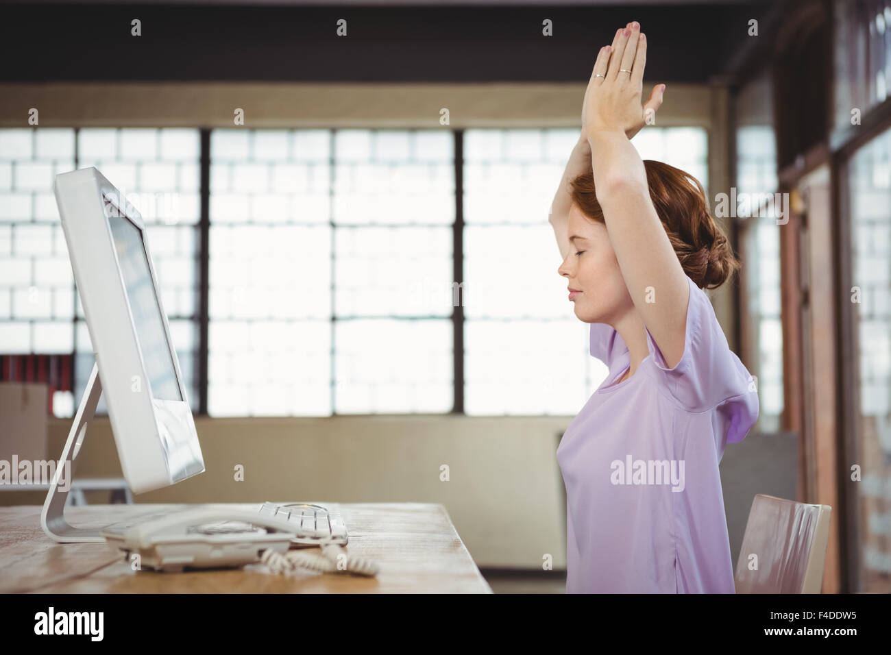 Businesswoman meditating in front of computer Stock Photo - Alamy