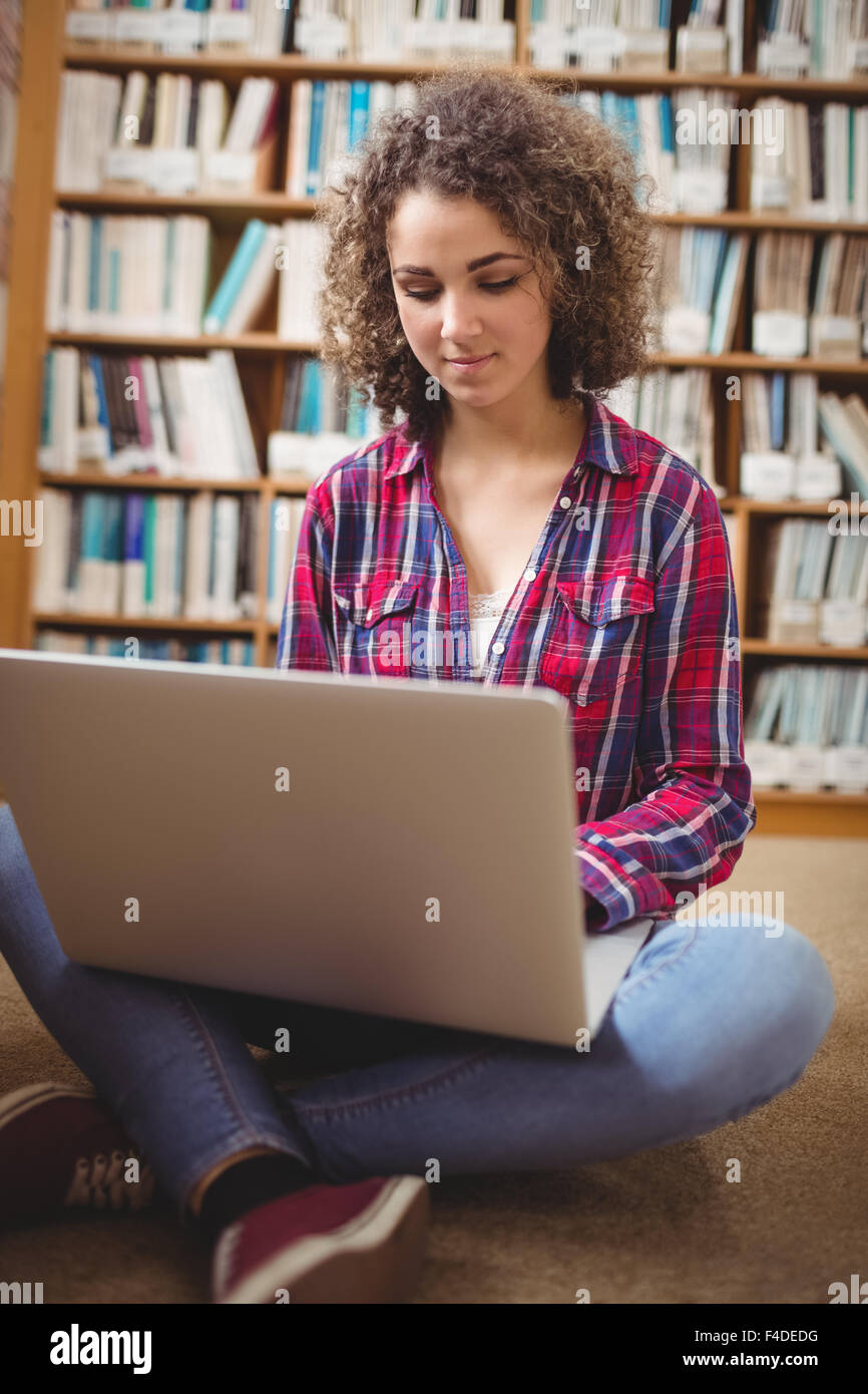 Pretty student in library using laptop Stock Photo - Alamy