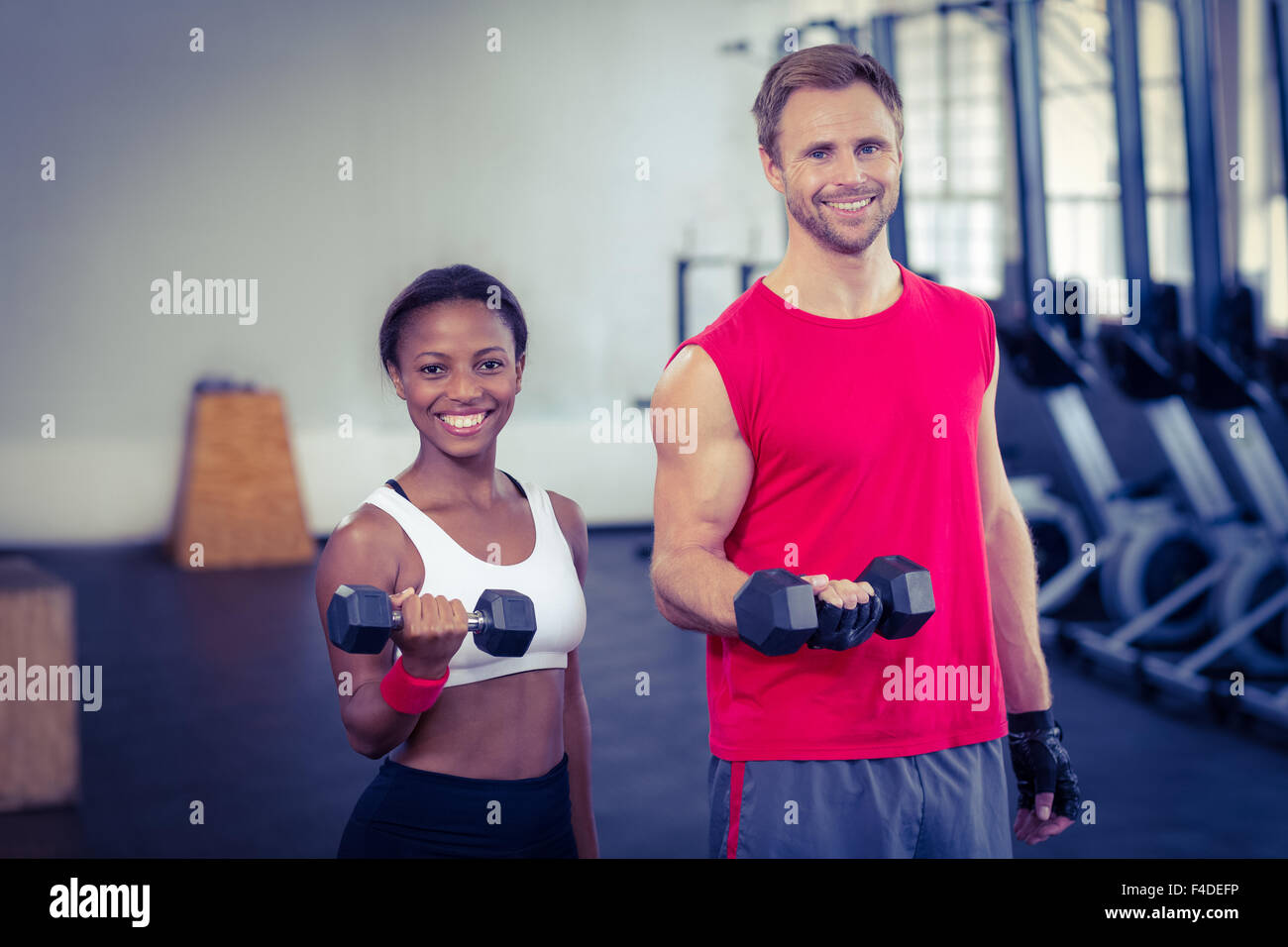 Muscular couple lifting weight together Stock Photo - Alamy