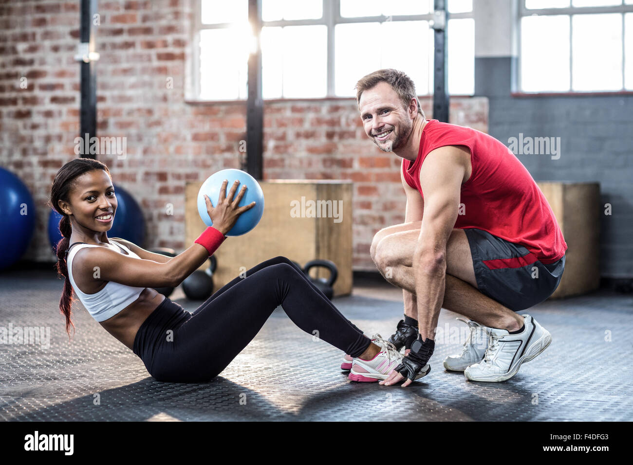 Muscular couple doing abdominal ball exercise Stock Photo - Alamy