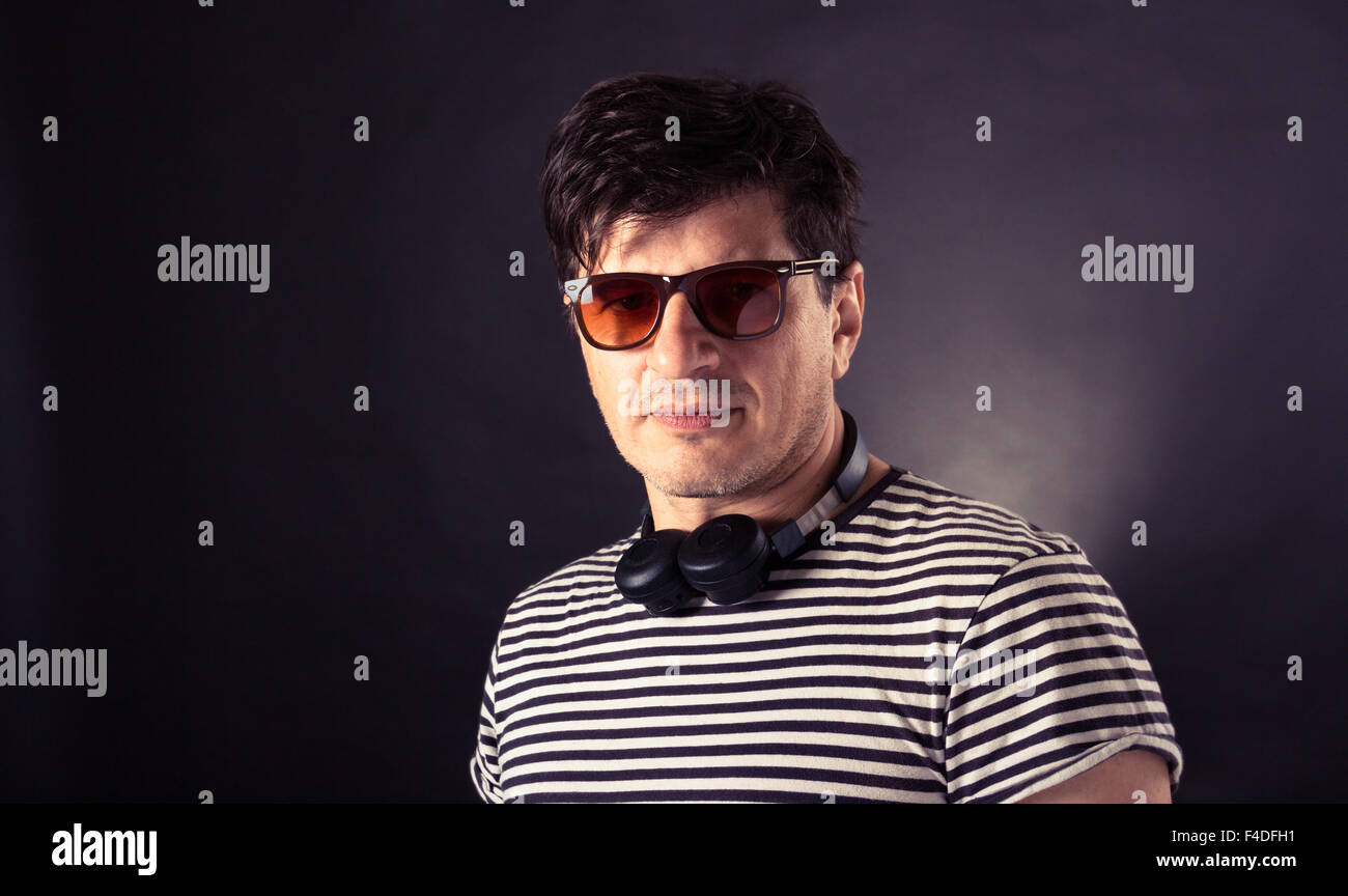 Handsome man in his 40's wearing bluetooth headphones and sunglasses ...