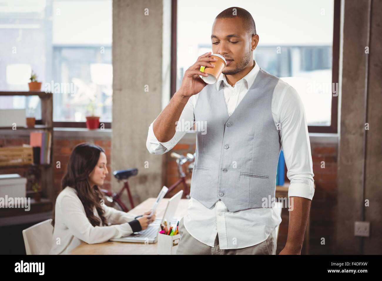 Businessman drinking coffee at office Stock Photo - Alamy