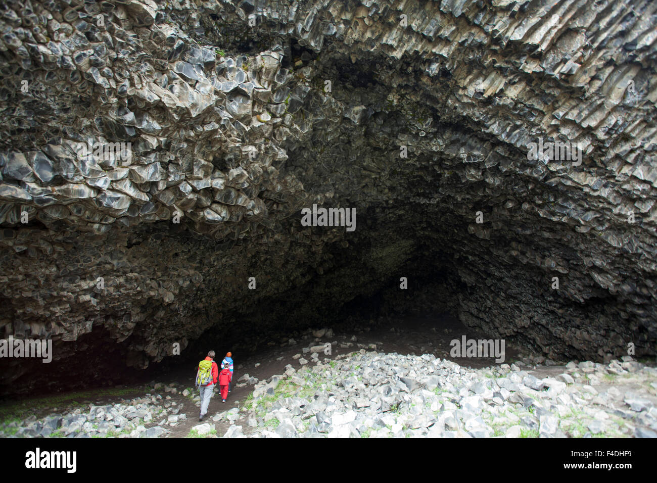 Family beneath the basalt cave of Kirkjan, Hljodaklettar ...